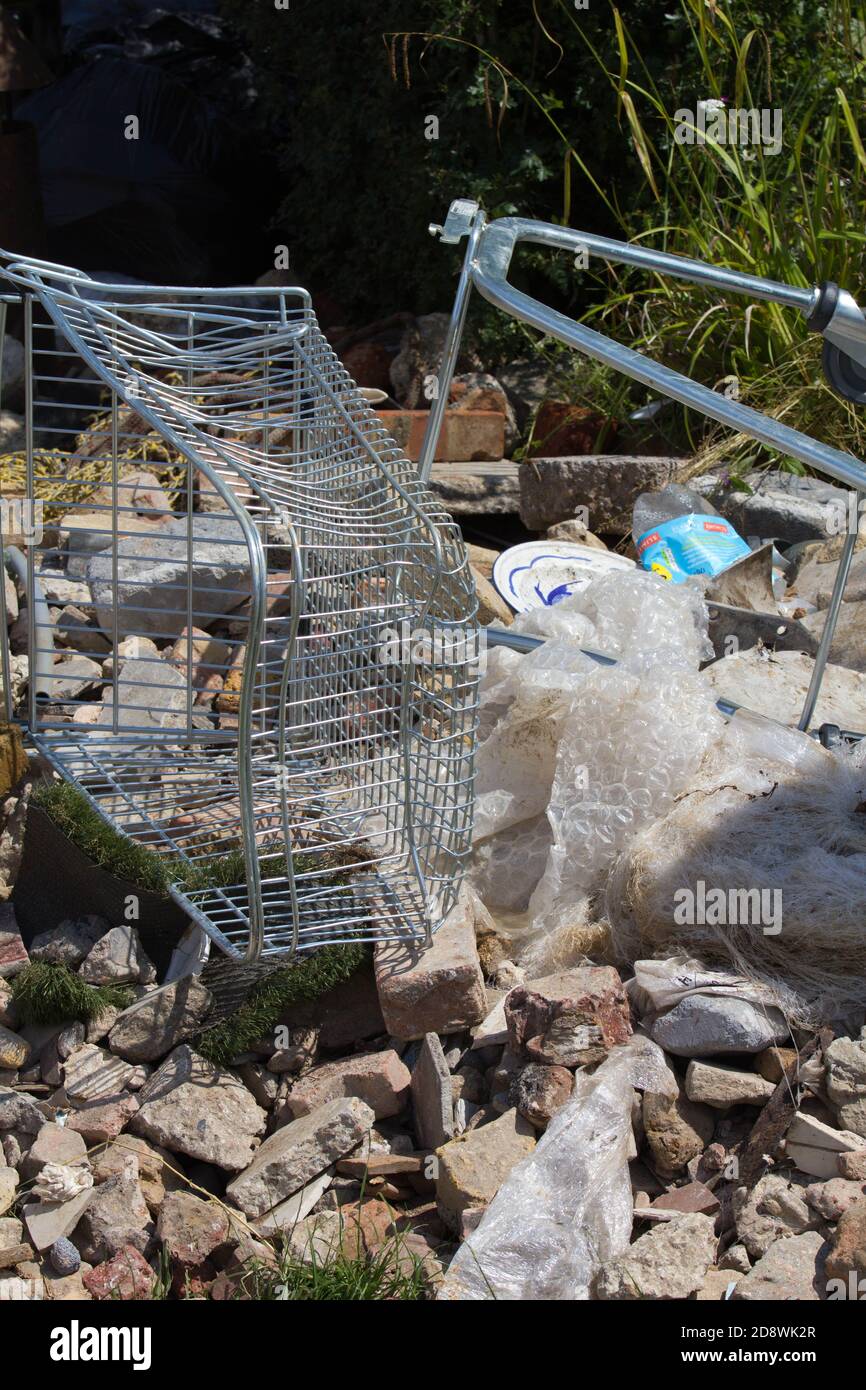 Discarded shopping trolley and assorted rubbish. A concept arrangement ...