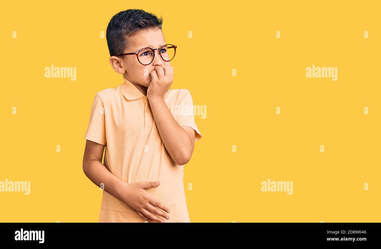 Little cute boy kid wearing casual clothes and glasses looking stressed ...