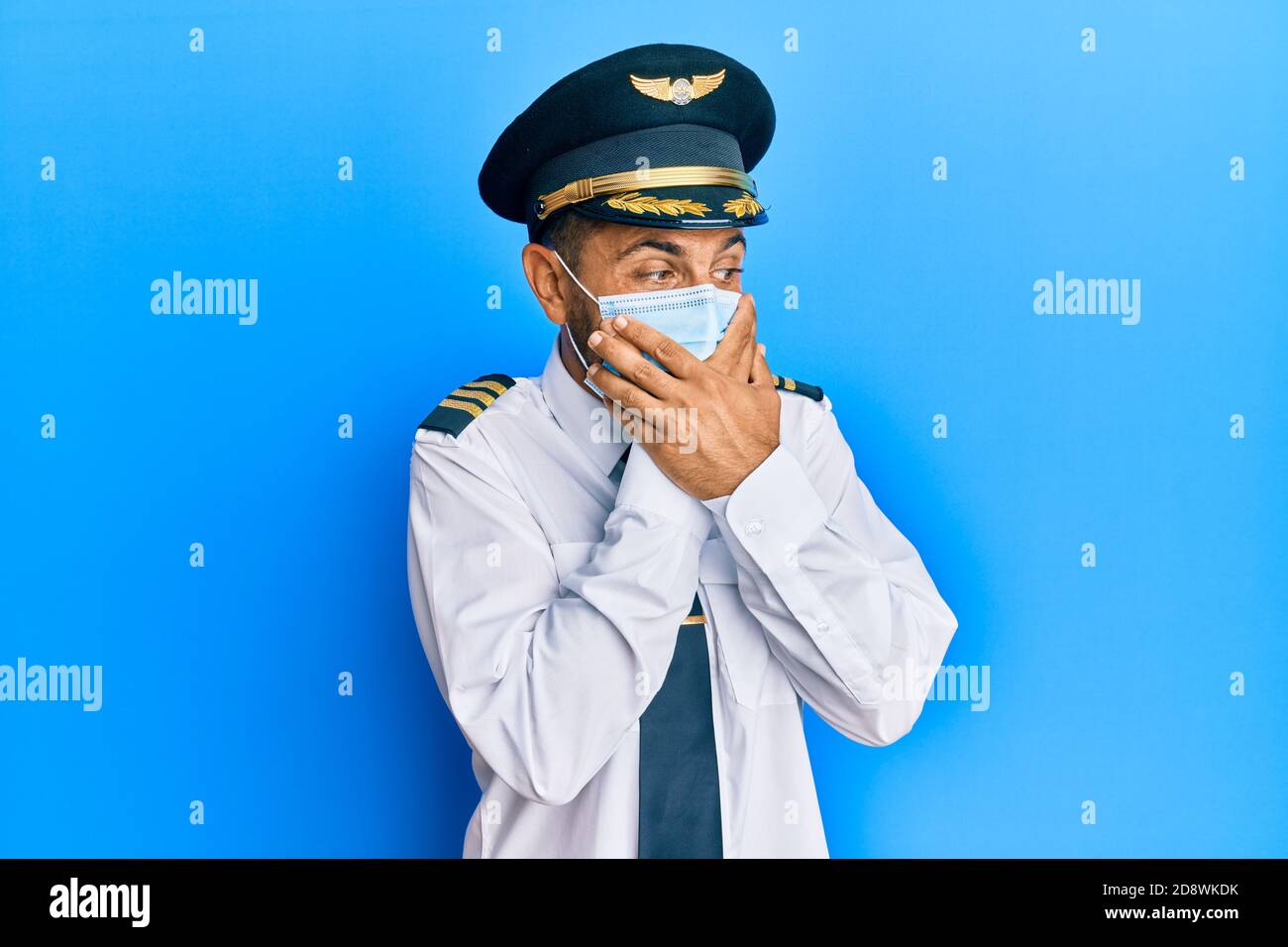 Handsome man with beard wearing airplane pilot uniform wearing safety ...
