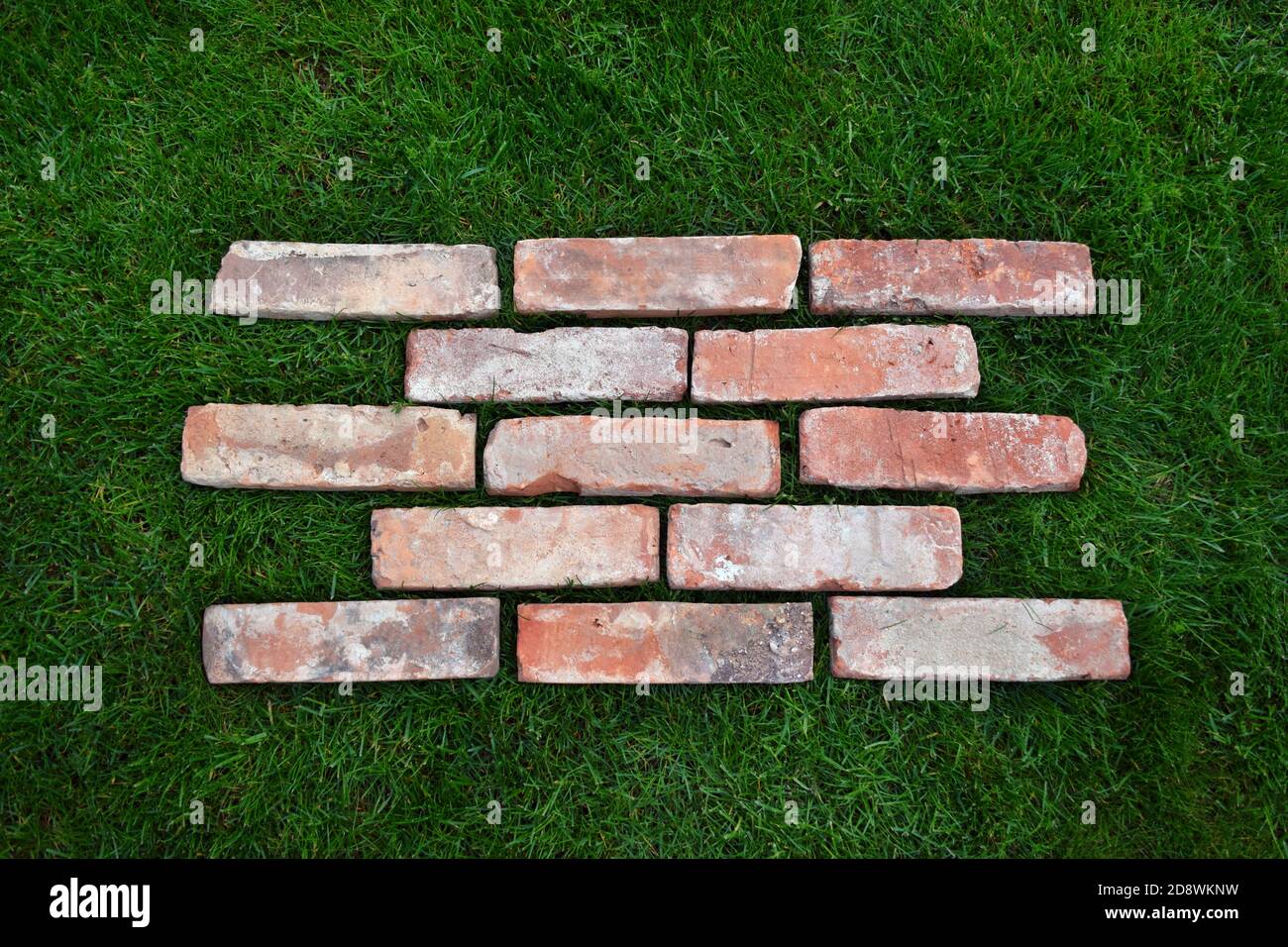 Cut red bricks range prepared to use design in the wall Stock Photo - Alamy