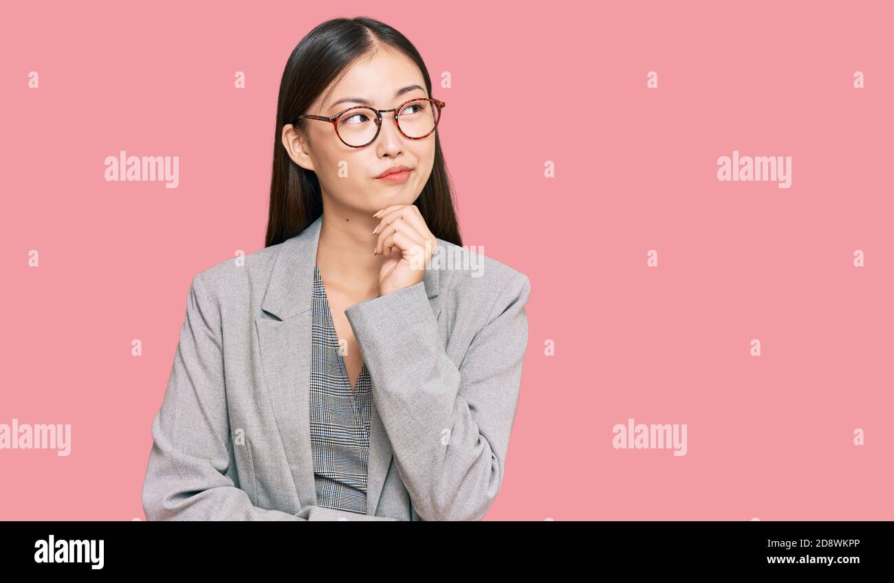 Young chinese woman wearing business clothes serious face thinking ...