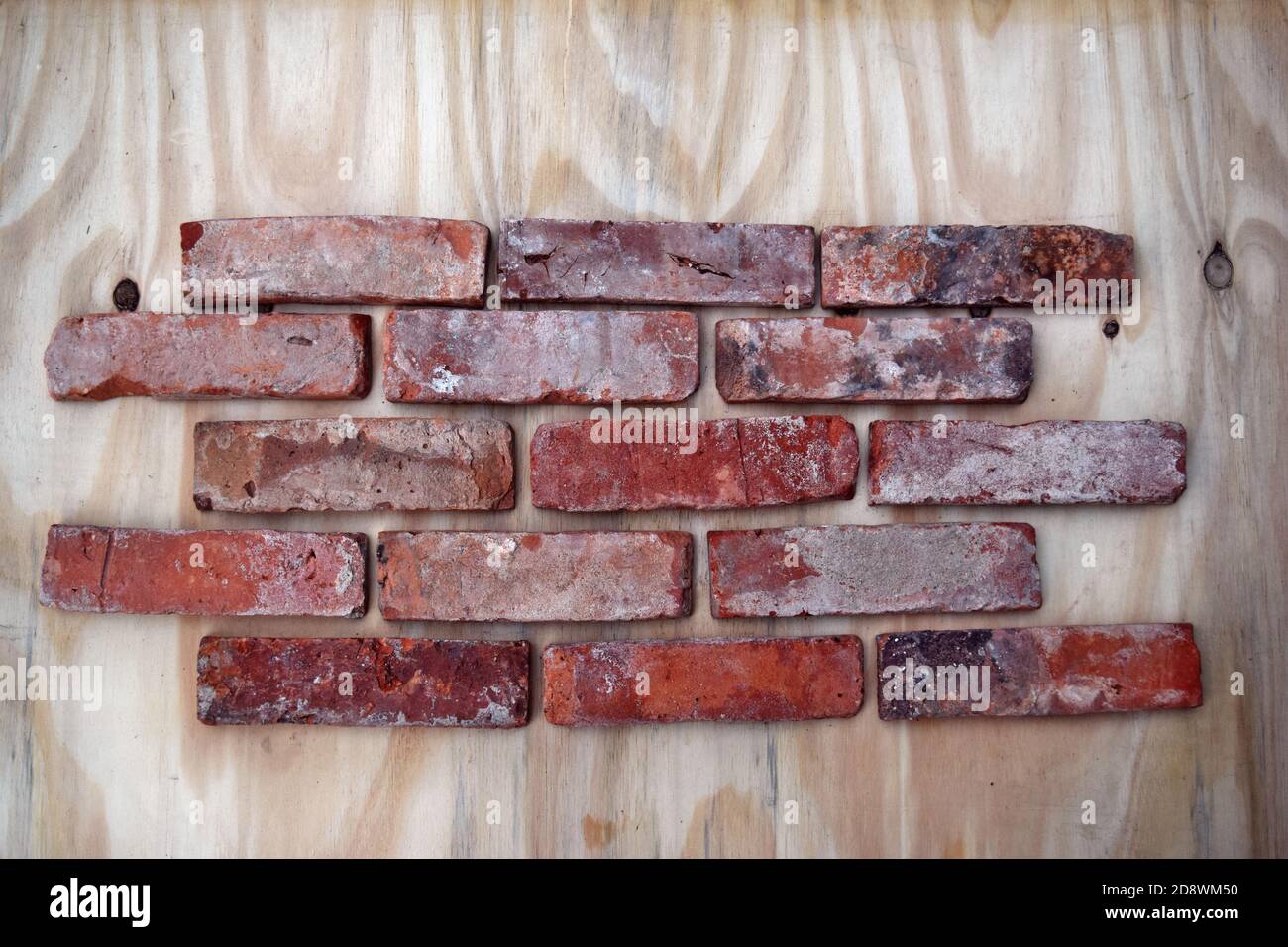 Cut red bricks range prepared to use design in the wall Stock Photo - Alamy