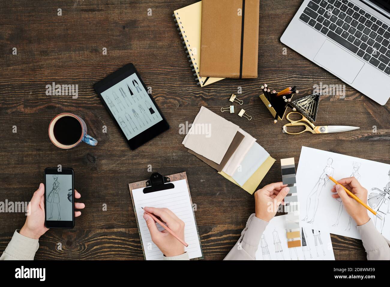 Flatlay of hands of male and female creative fashion designers working ...