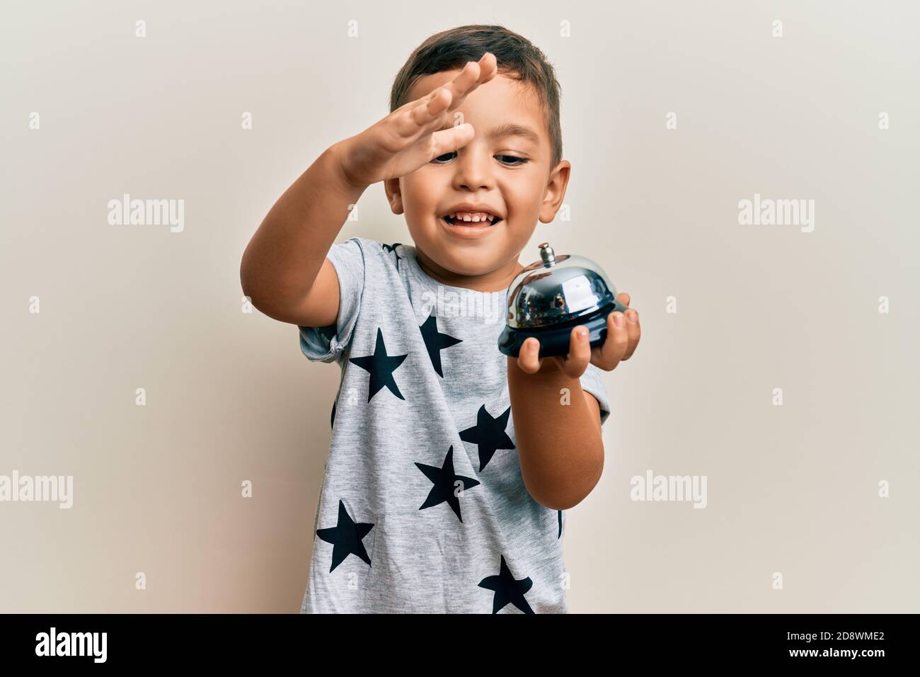 Adorable latin toddler smiling happy using receptionist ring bell over ...