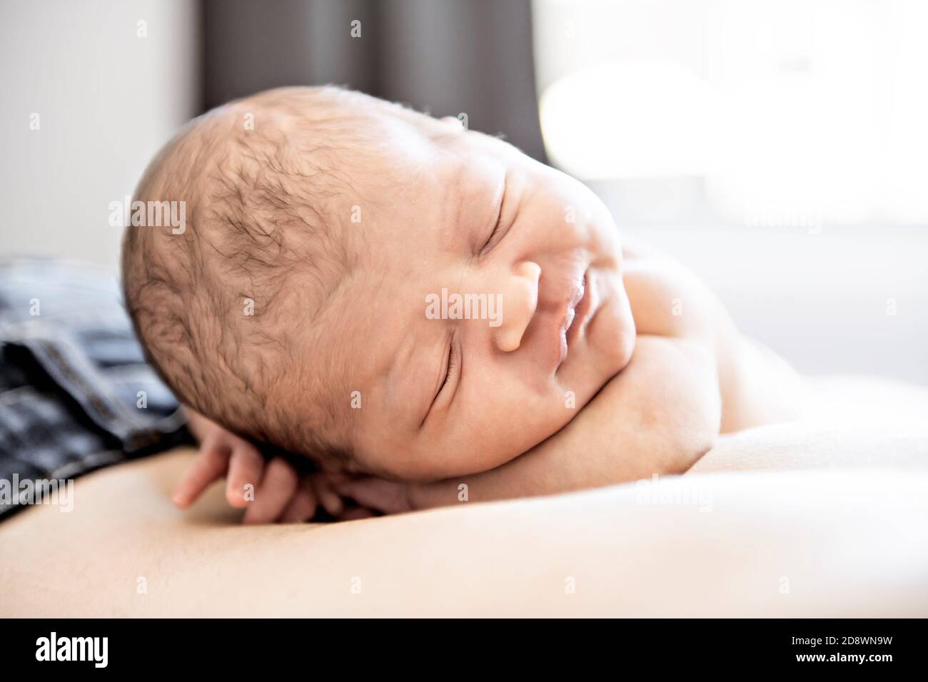 A newborn baby laying down sleeping on the father back Stock Photo - Alamy
