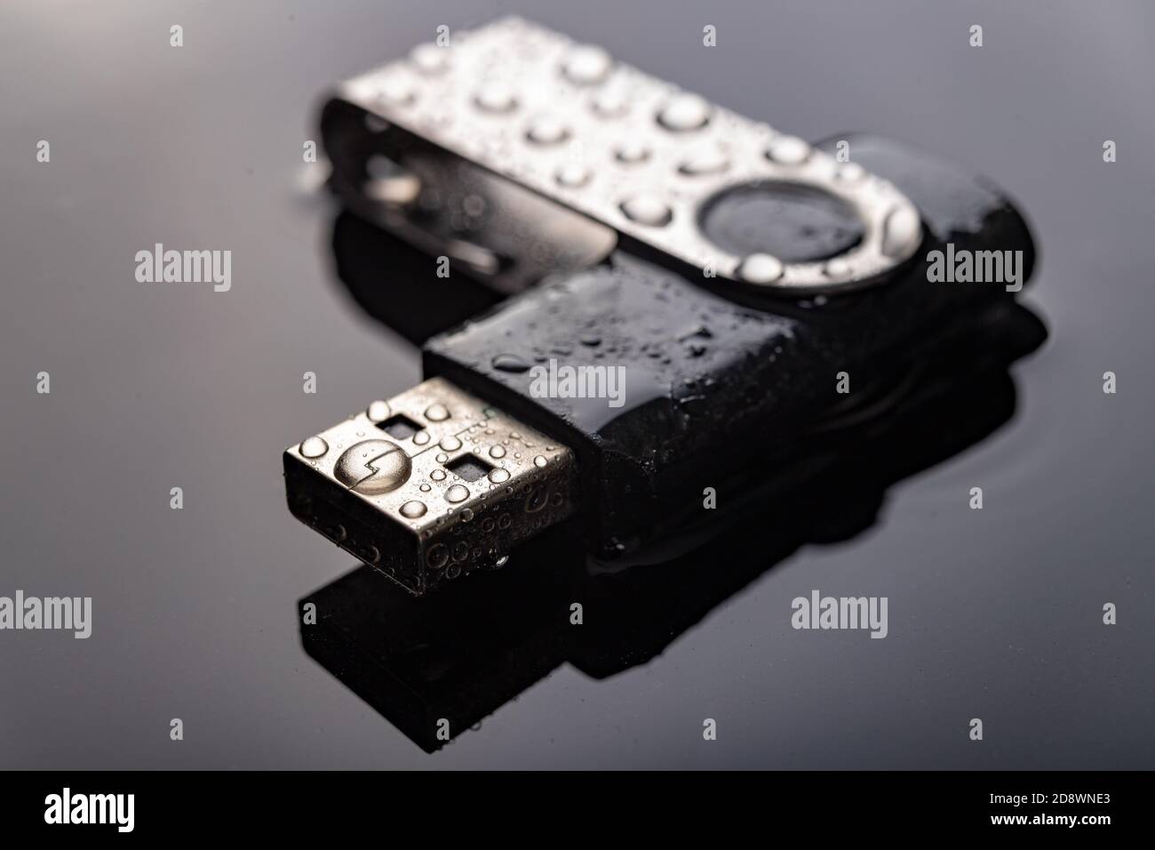 USB flash drive with water drops on the table. Electronic data storage ...