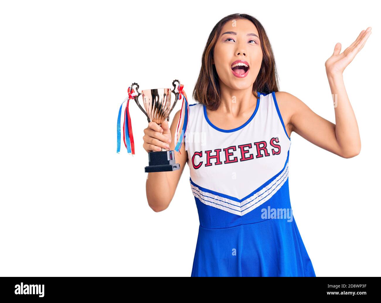 Youn beautiful asian girl wearing cheerleader uniform holding champion ...