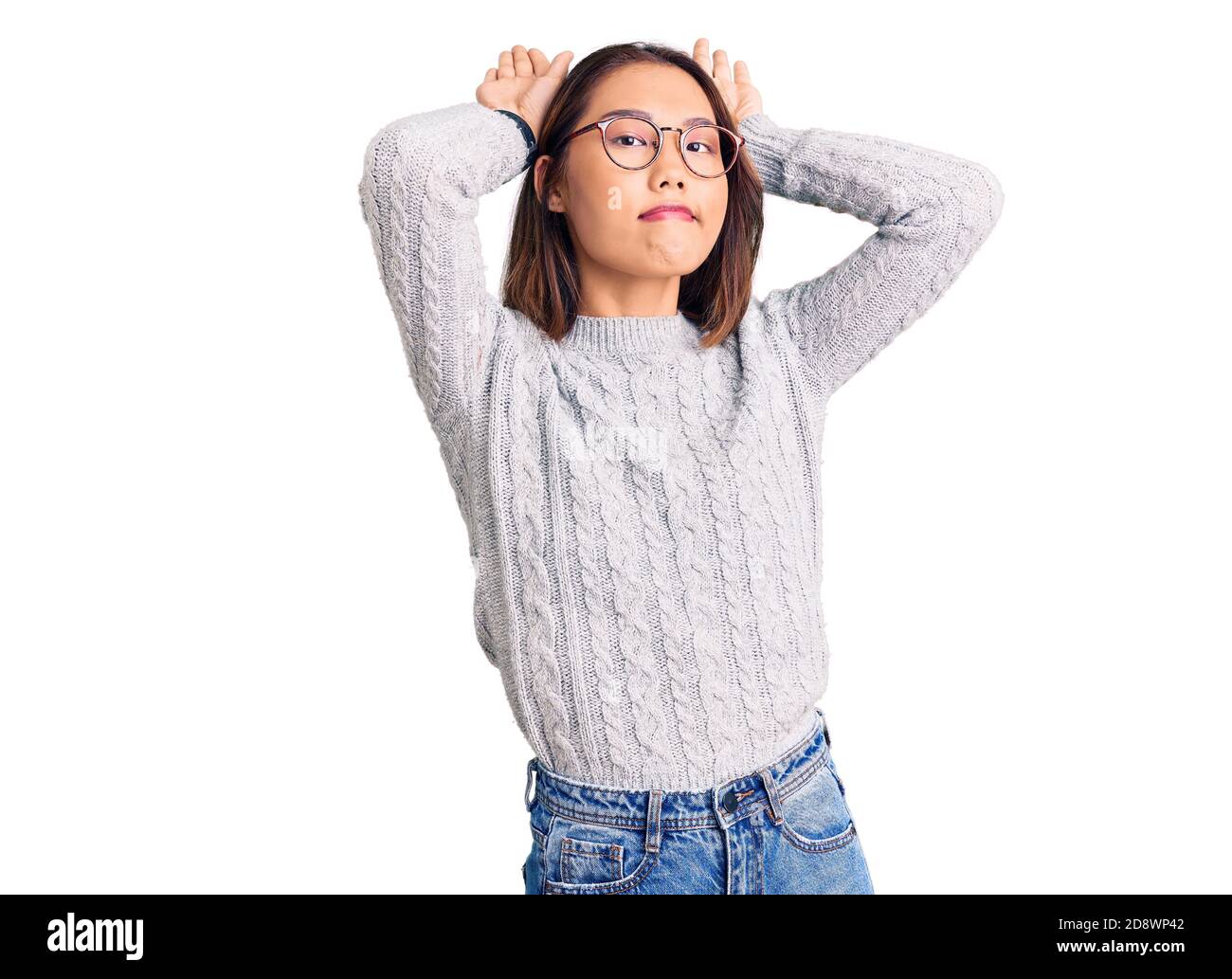 Young beautiful chinese girl wearing casual clothes doing bunny ears ...