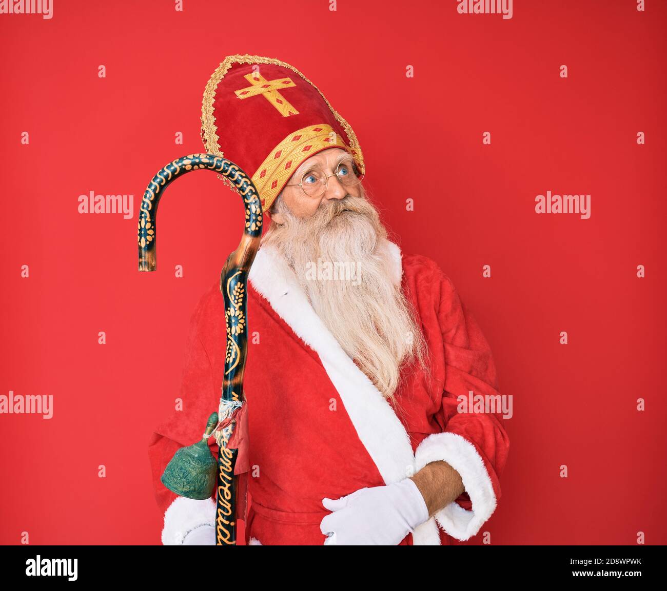 Old senior man with grey hair and long beard wearing traditional saint ...