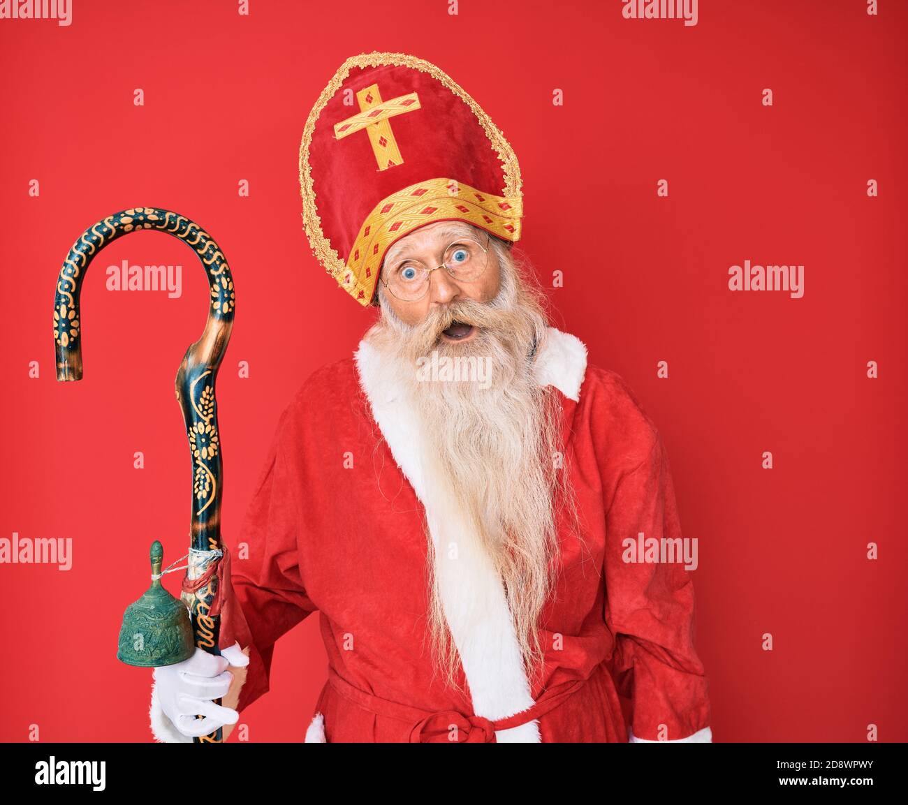 Old senior man with grey hair and long beard wearing traditional saint ...