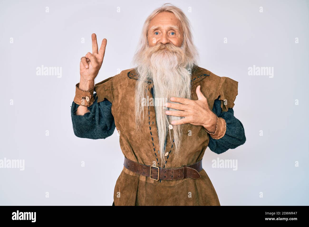 Old senior man with grey hair and long beard wearing viking traditional ...