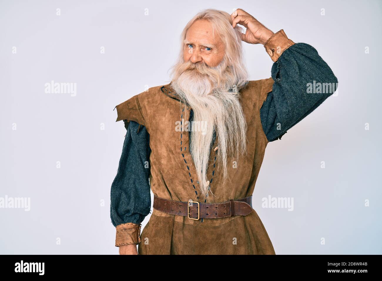 Old senior man with grey hair and long beard wearing viking traditional ...