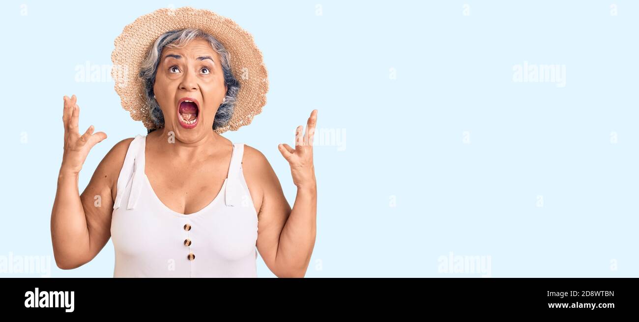 Senior woman with gray hair wearing summer hat and summer clothes crazy ...