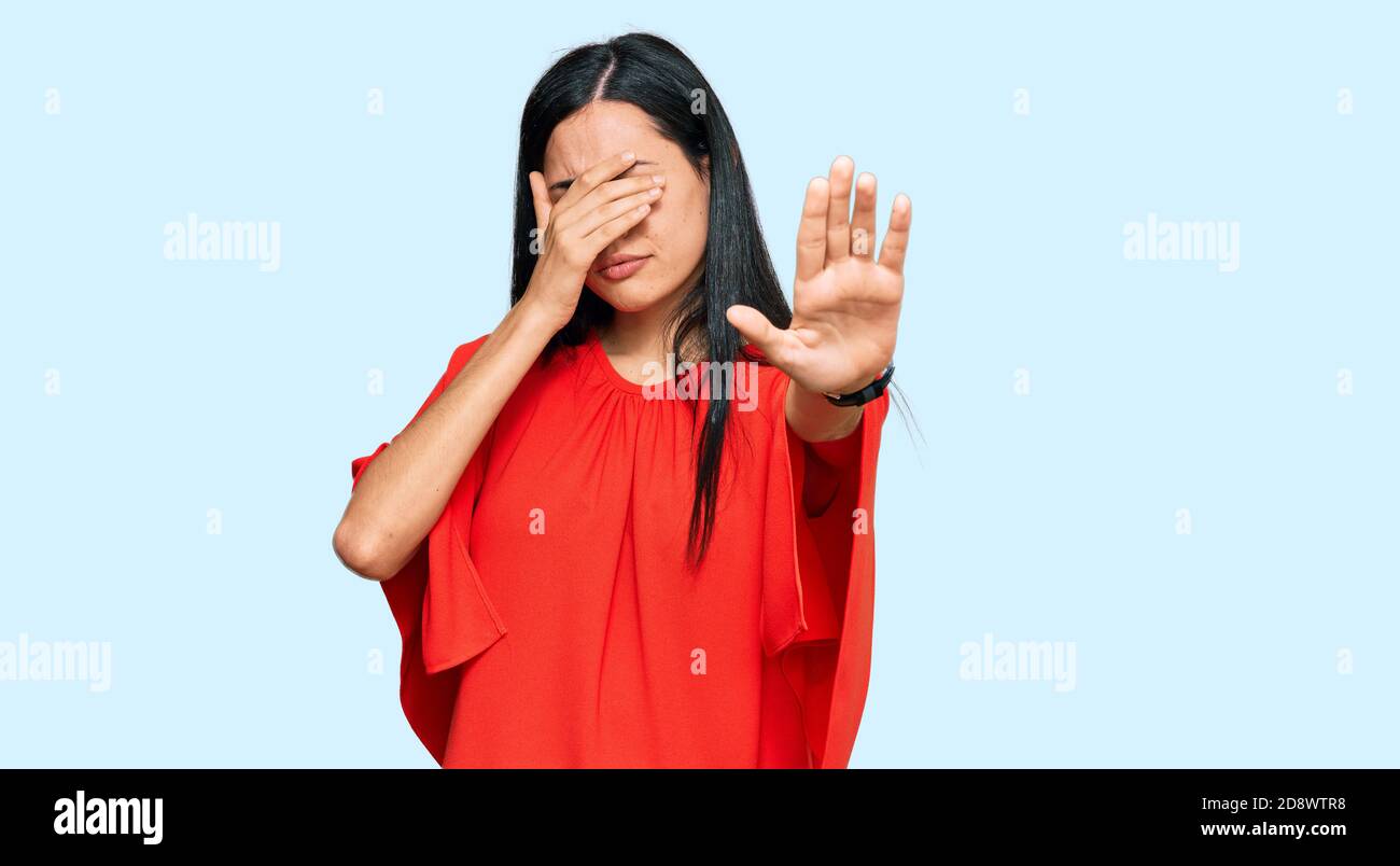 Beautiful young woman wearing casual clothes covering eyes with hands ...