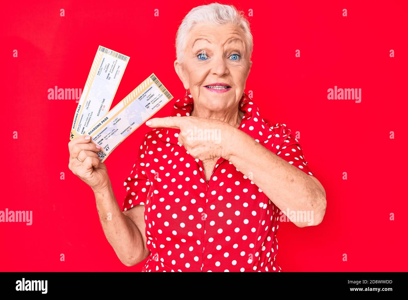 Senior beautiful woman with blue eyes and grey hair holding boarding ...