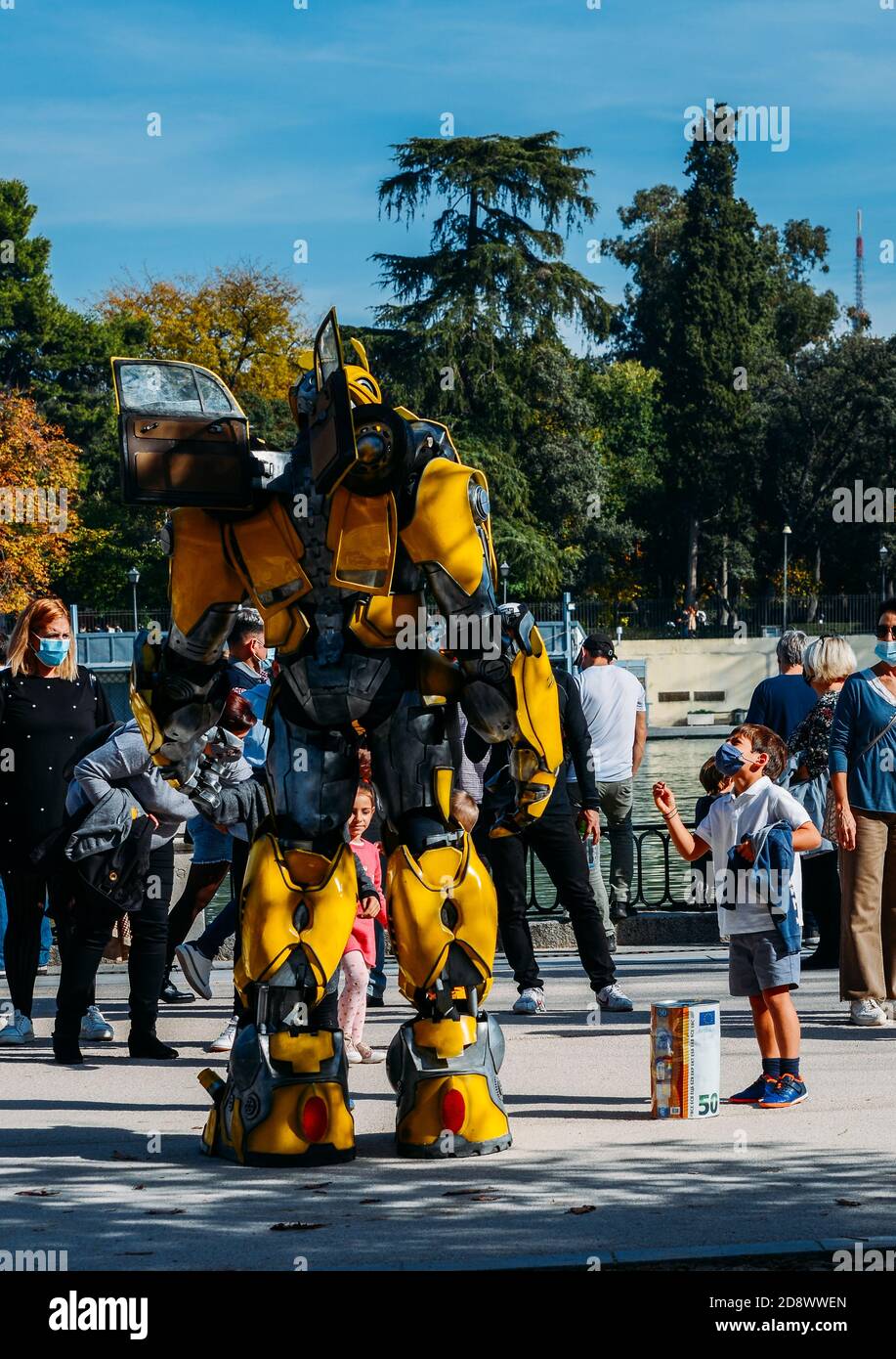 Transformers street performer receives a coin from a child at Retiro ...