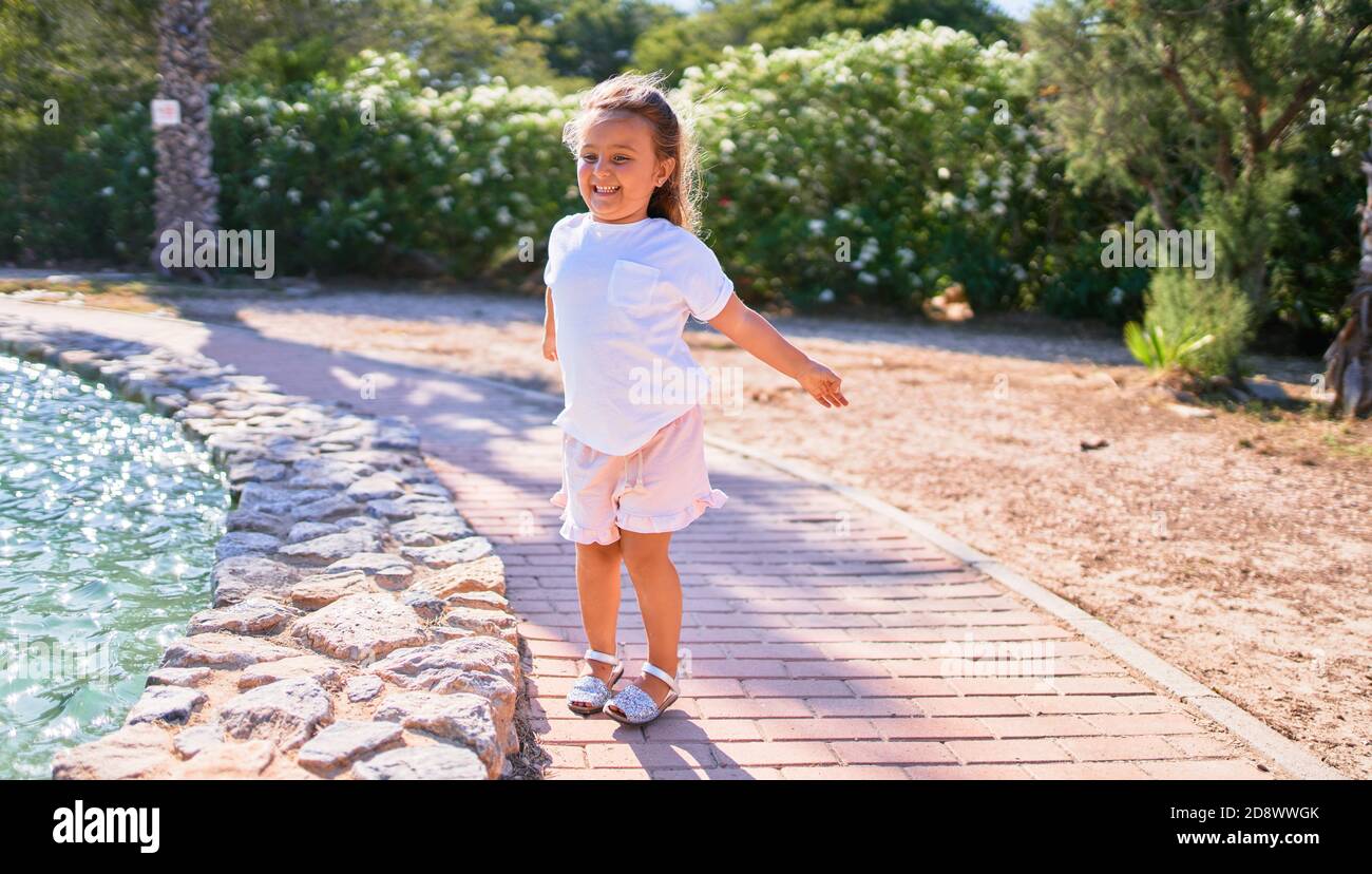 Adorable blonde child smiling happy. Standing with smile on face around ...