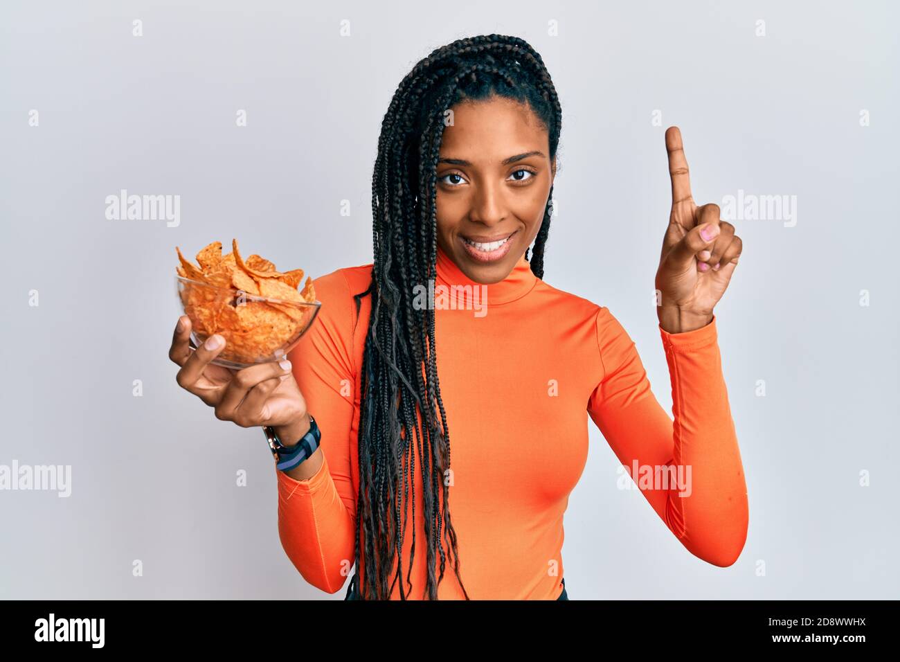 African american woman holding nachos potato chips smiling with an idea ...