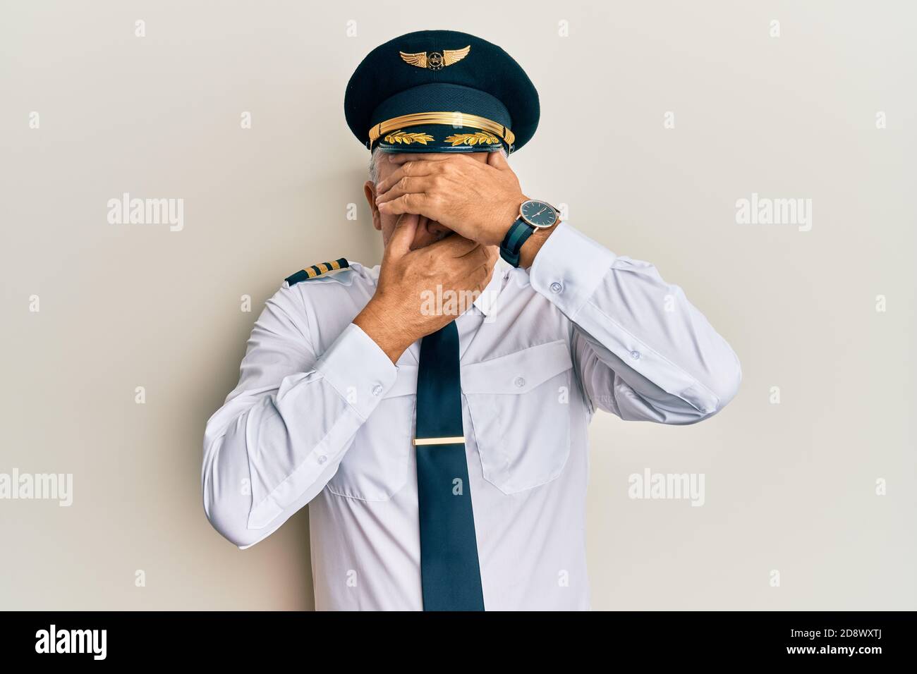 Handsome middle age mature man wearing airplane pilot uniform covering ...