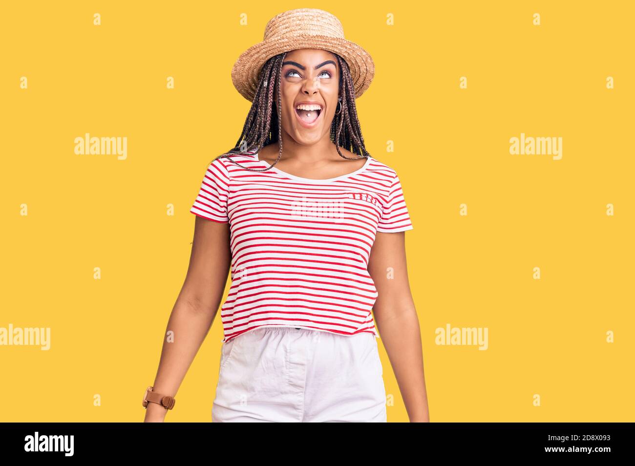 Young african american woman with braids wearing summer hat angry and ...