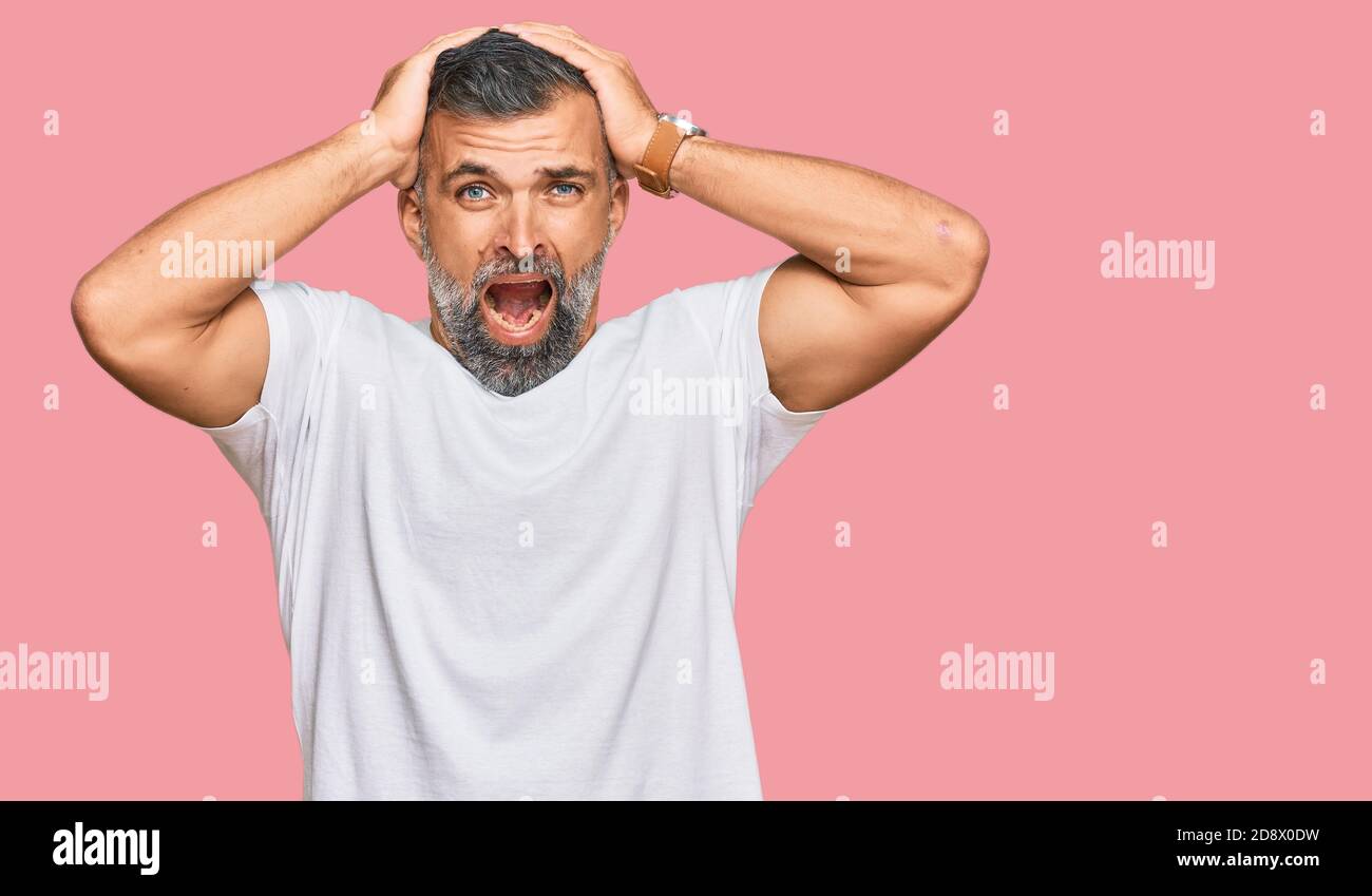 Middle age handsome man wearing casual white tshirt crazy and scared ...