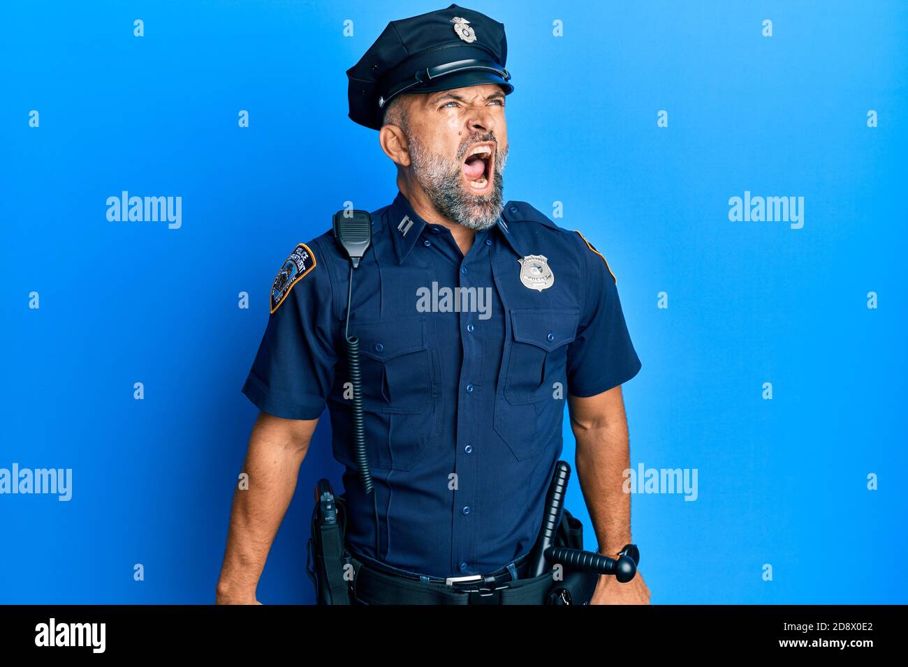 Middle age handsome man wearing police uniform angry and mad screaming ...