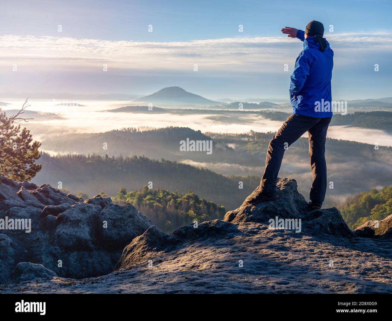 Man shadowing eyes. Alone tourist with grey cap stand on cliff edge and ...