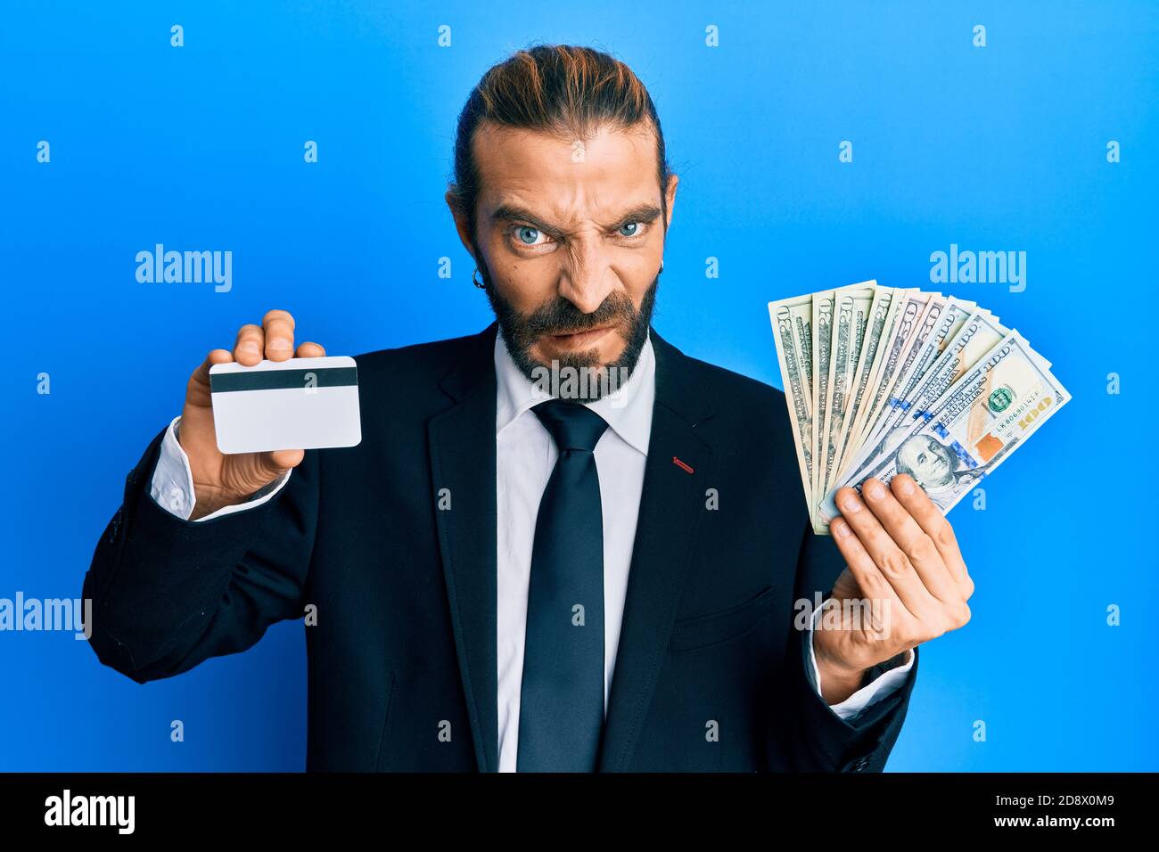 Attractive business man with long hair and beard holding credit card ...