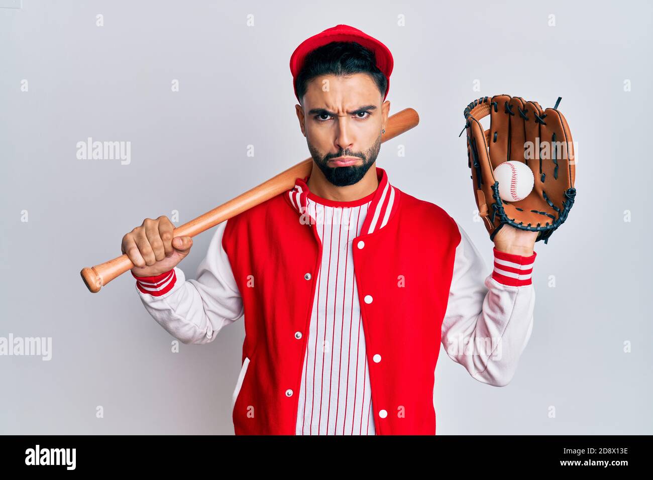 Young man with beard playing baseball holding bat and ball depressed ...