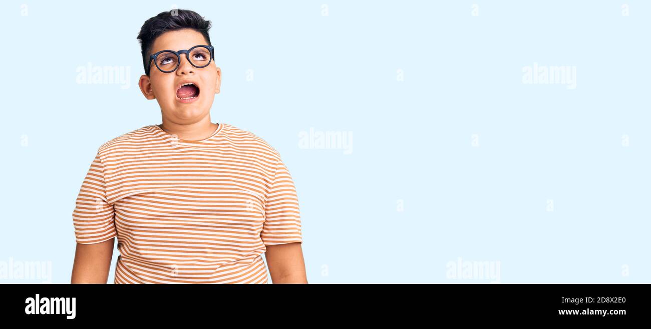 Little boy kid wearing casual clothes and glasses angry and mad ...