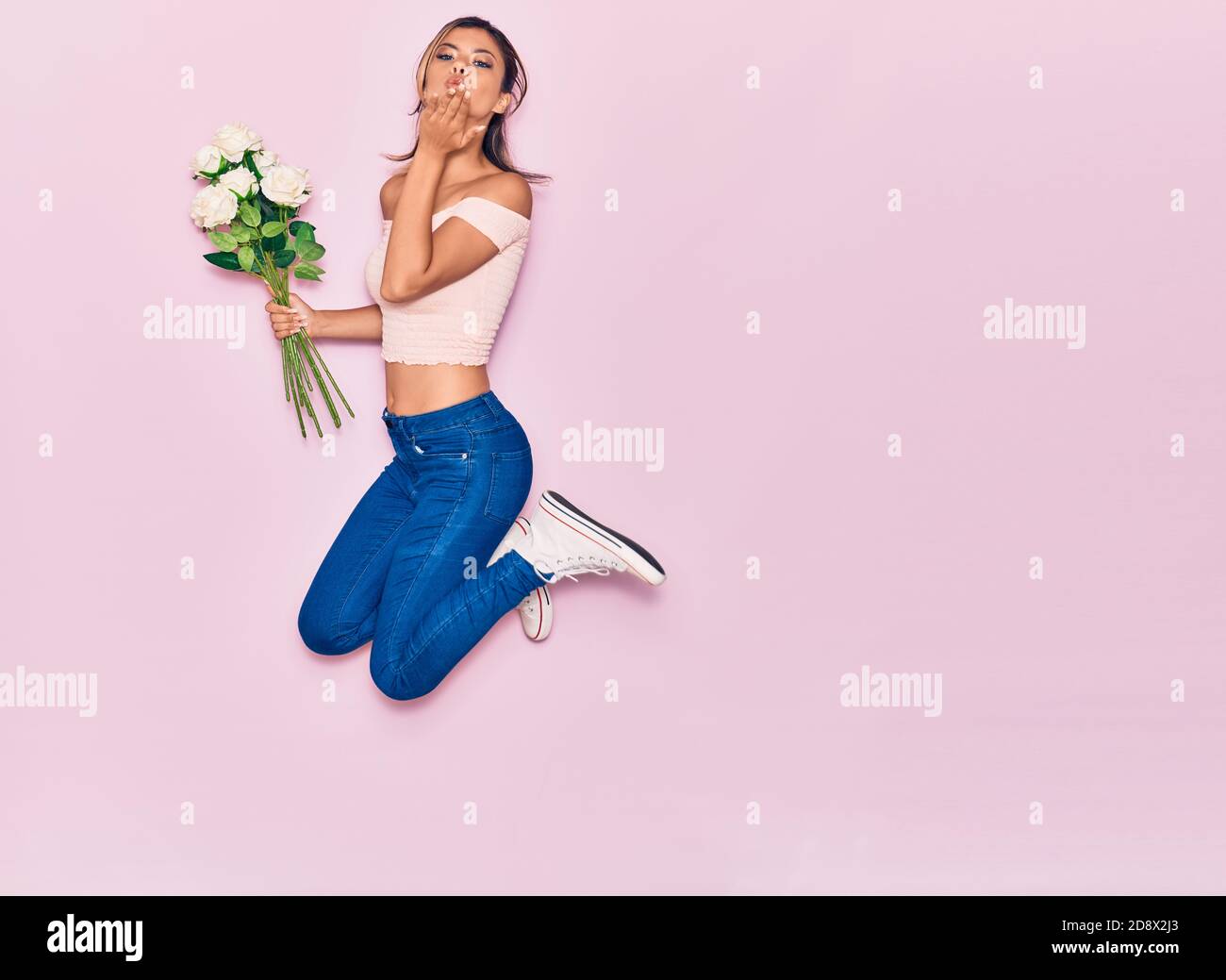 Young beautiful girl holding bouquet of flowers. Throwing kiss with ...