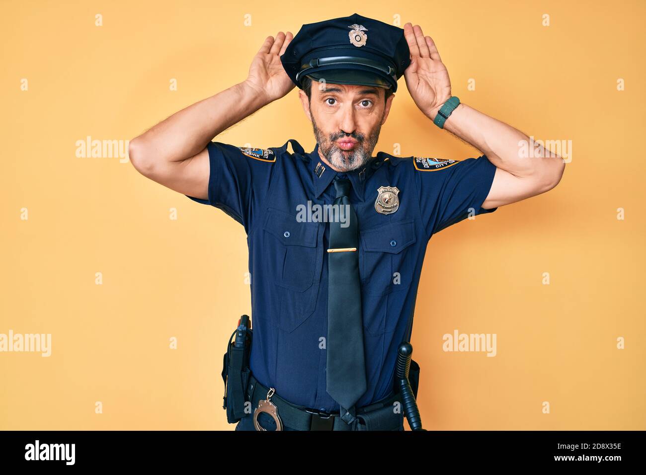 Middle age hispanic man wearing police uniform doing bunny ears gesture ...