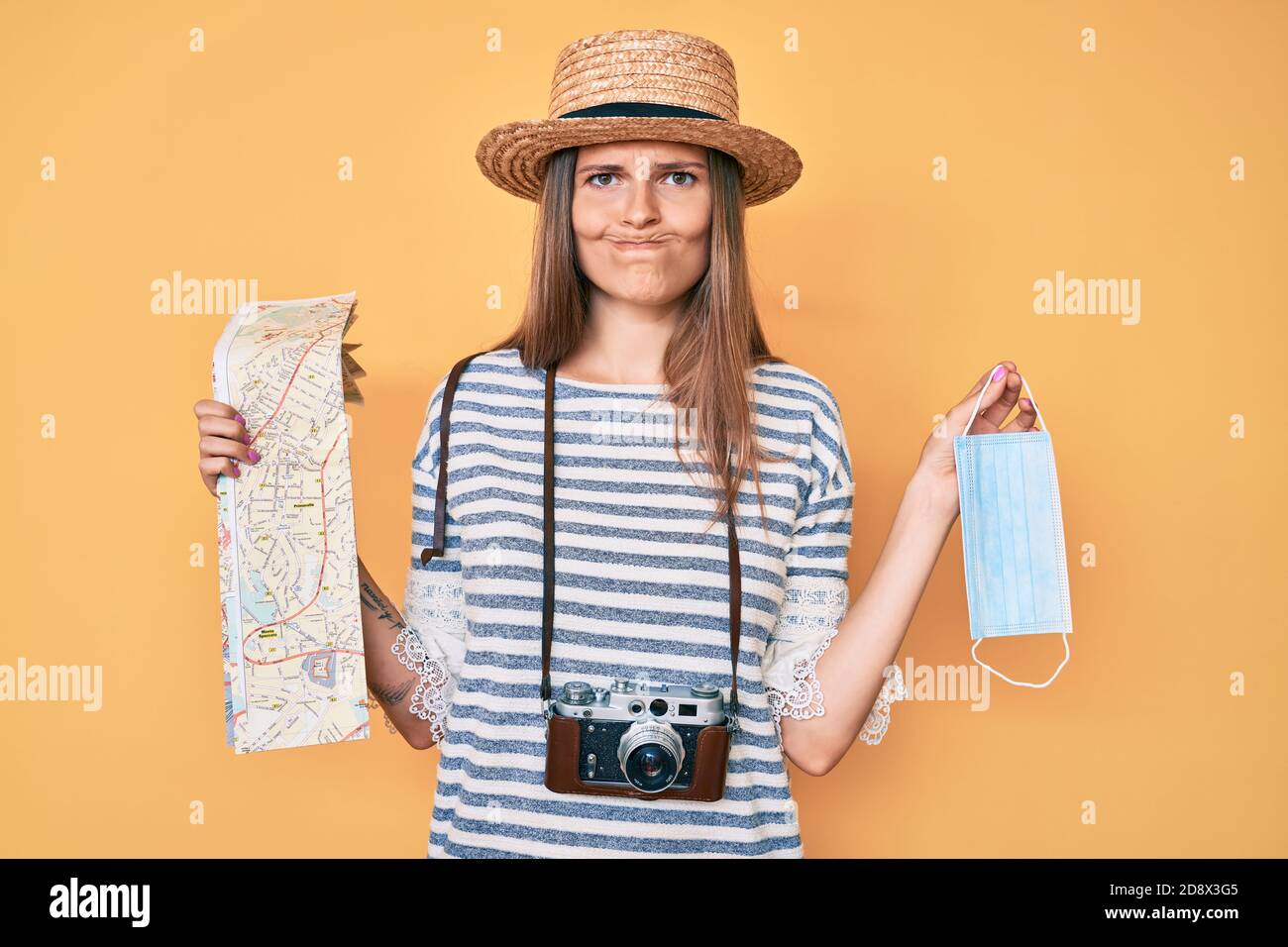 Beautiful caucasian tourist woman holding coronavirus safety mask ...