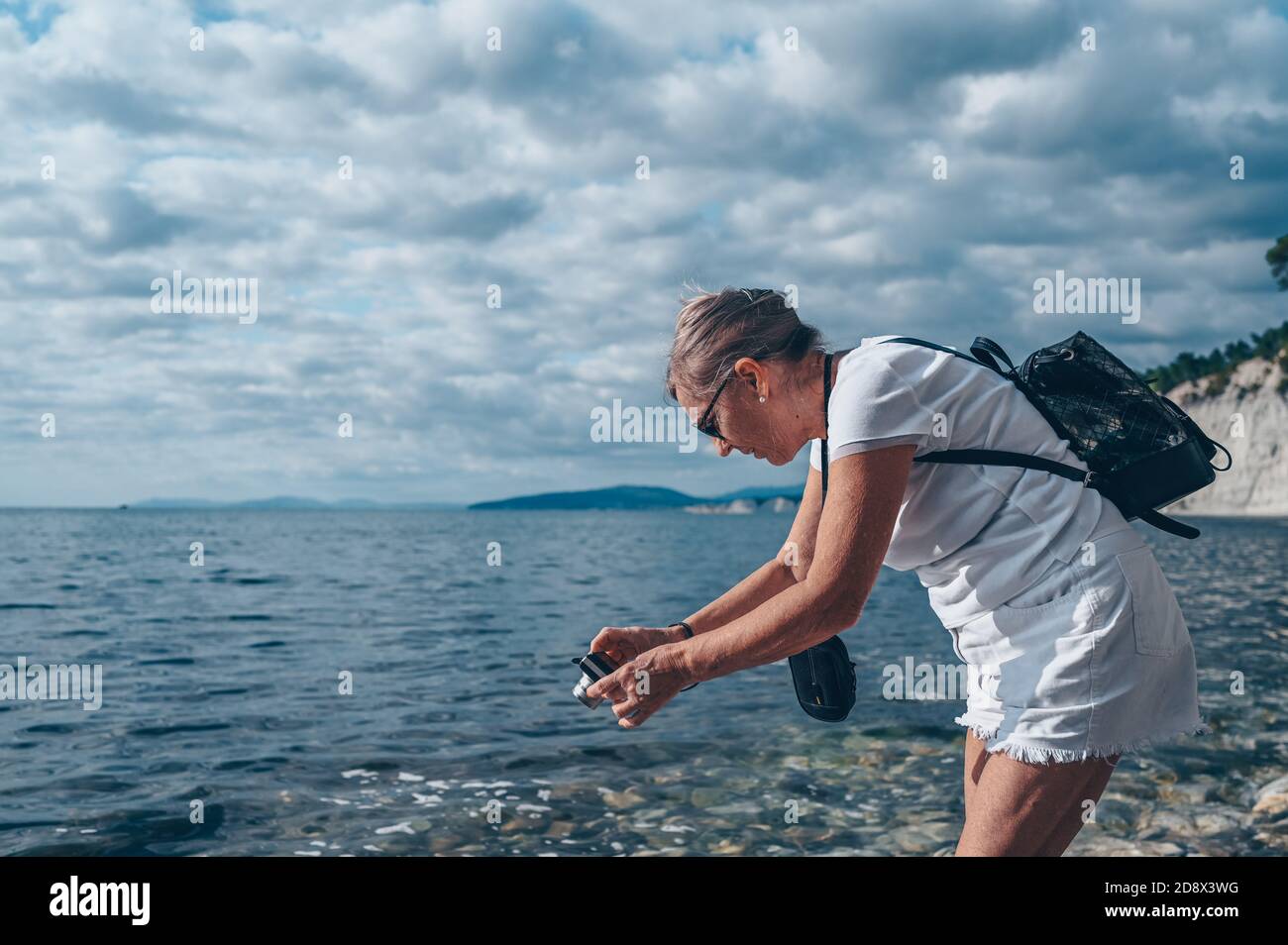Elderly senior traveling backpacker mature woman tourist walking taking ...