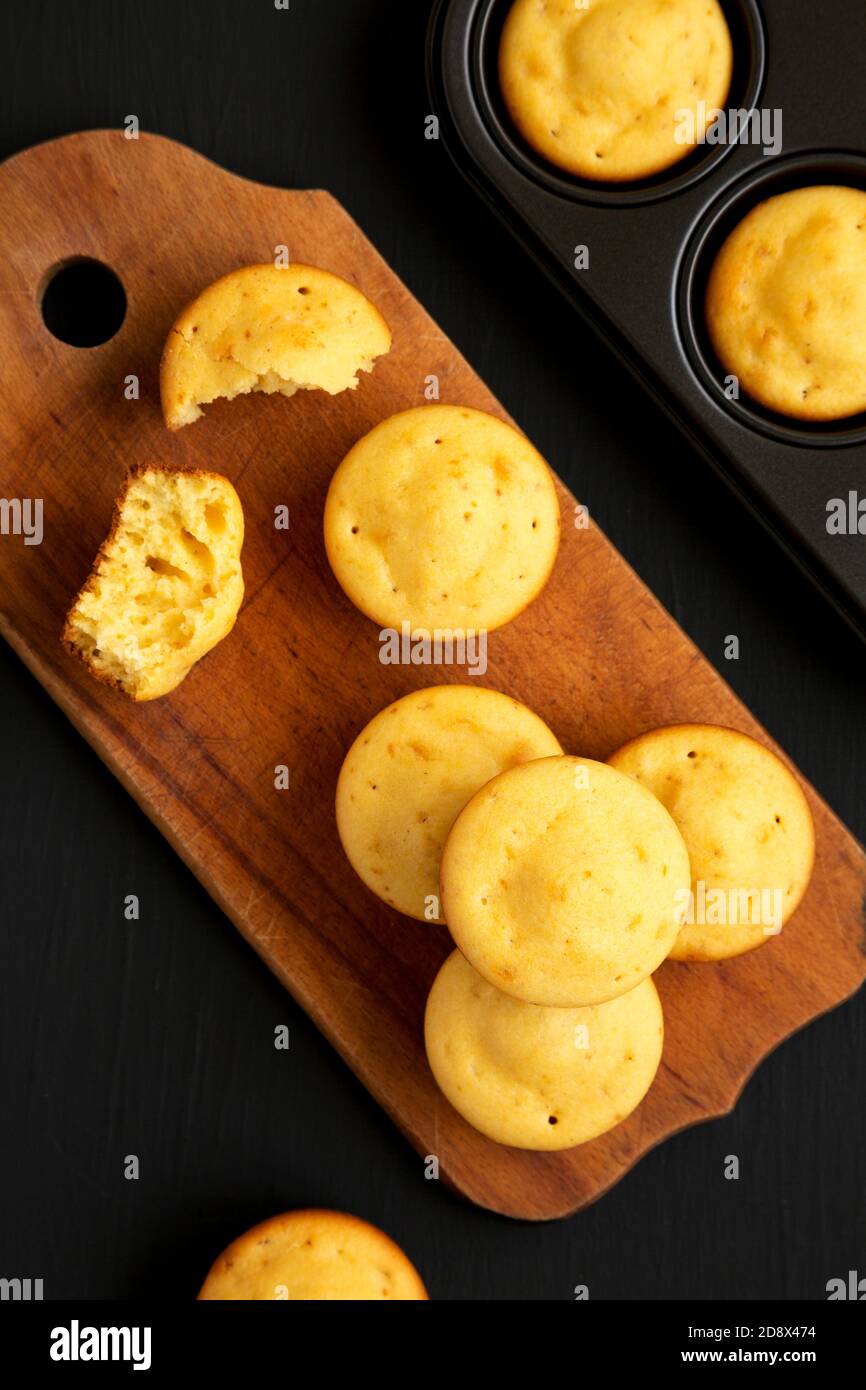 Homemade Cornbread Muffins on a rustic wooden board on a black ...