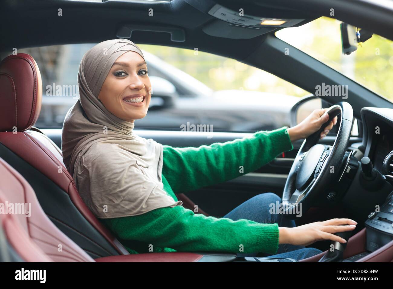 Smiling muslim woman driving her new car Stock Photo - Alamy
