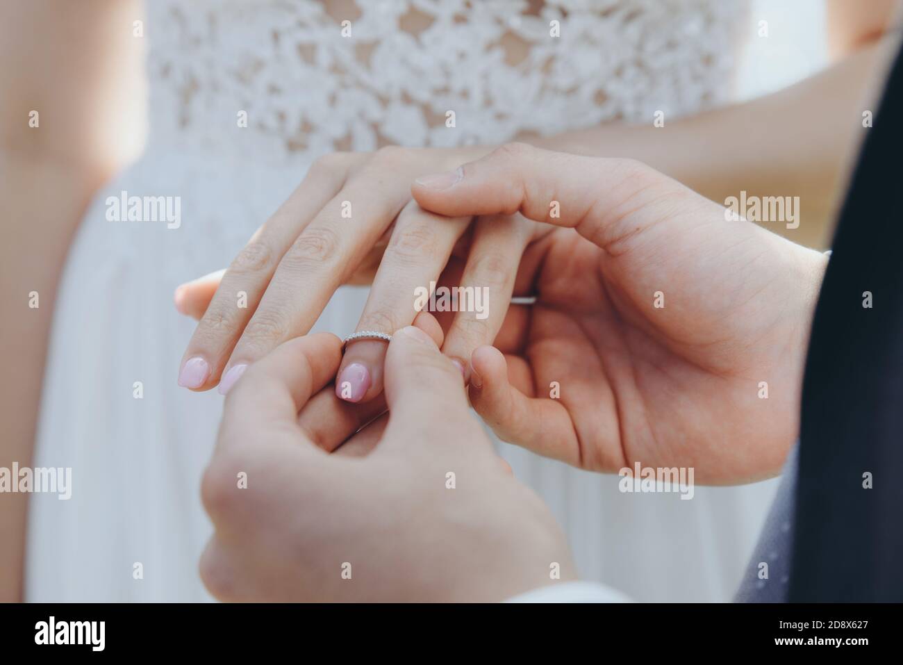 Beautiful bridal couple putting the wedding rings on Stock Photo - Alamy