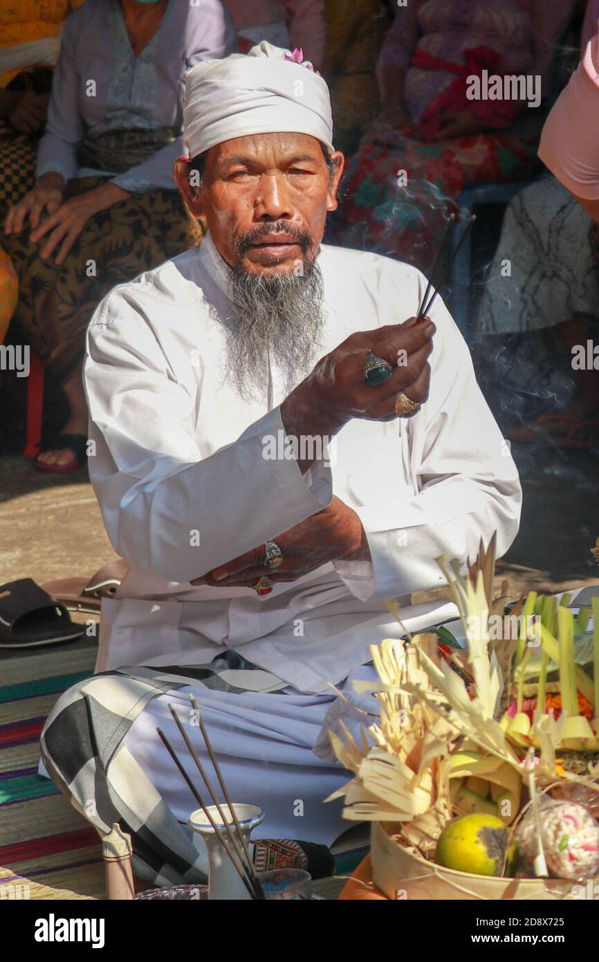 Front view to hindu priest during ceremony. Pedanda sits in front of ...