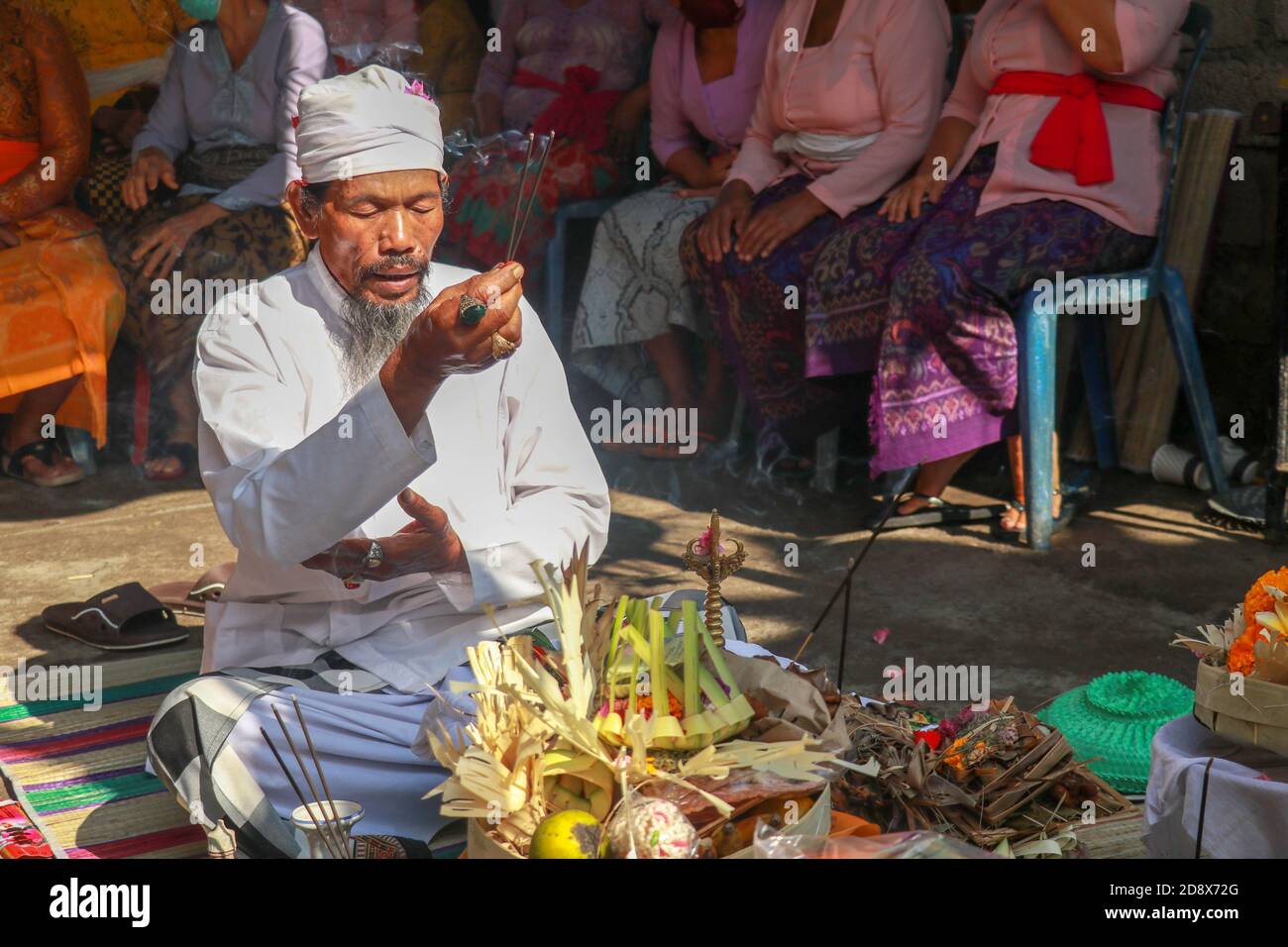 Front view to hindu priest during ceremony. Pedanda sits in front of ...