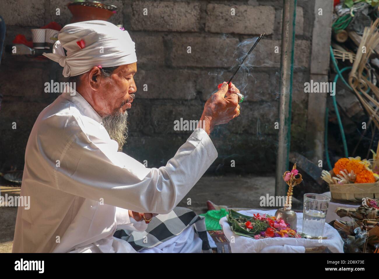 Close up of a Balinese pedanda during prayer. side view of a hindu ...
