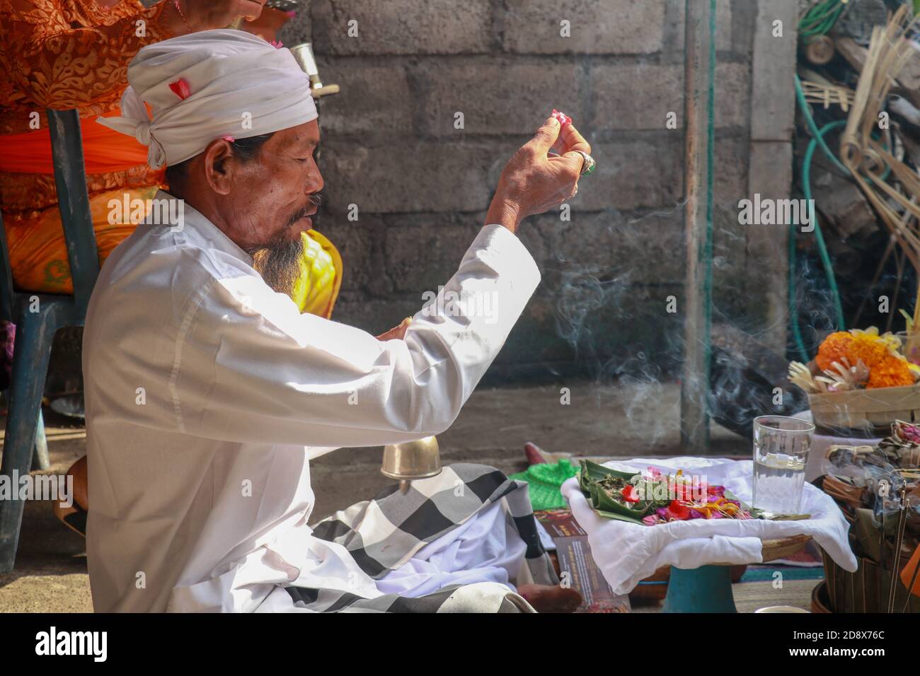 Close up of a Balinese pedanda during prayer. side view of a hindu ...