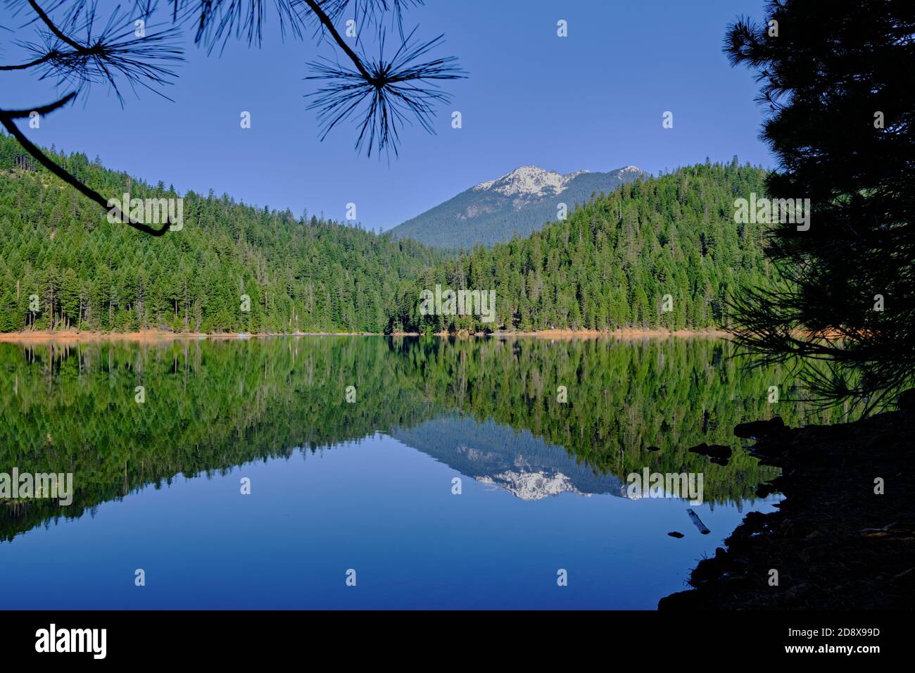 Waters of Trinity Lake are perfectly calm allowing a mirror-image ...