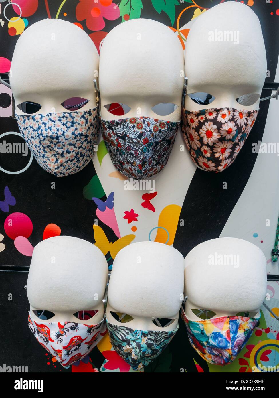 Vertical shot of face masks with colorful paintings on plastic faces ...