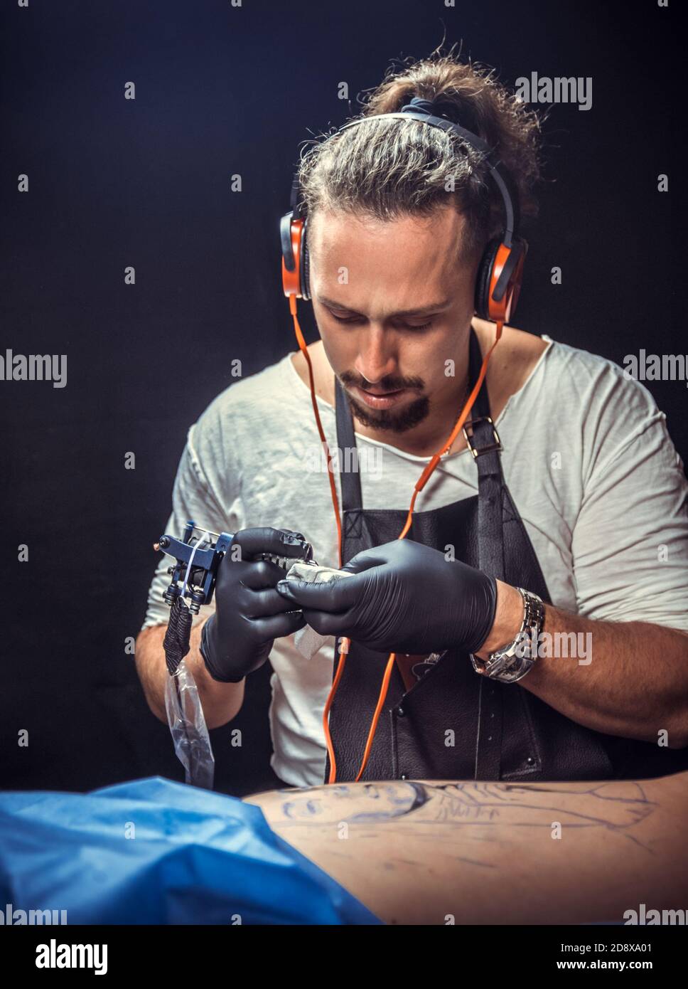 Master of the art of tattooing demonstrates the process of getting ...