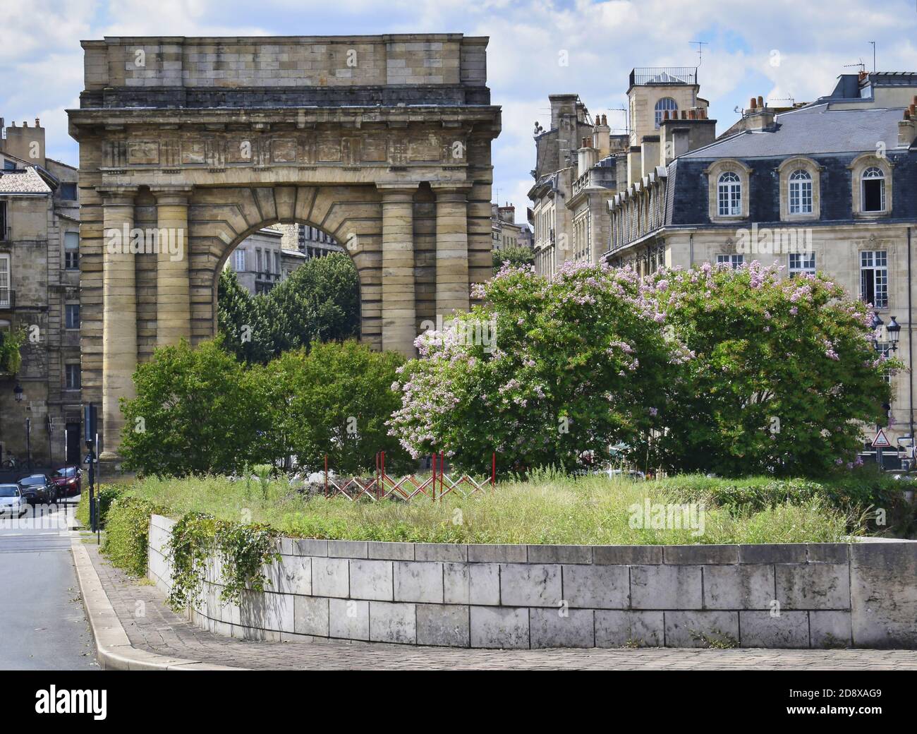 View of the Burgundy Gate behind bushes at a street in Bordeaux, France ...
