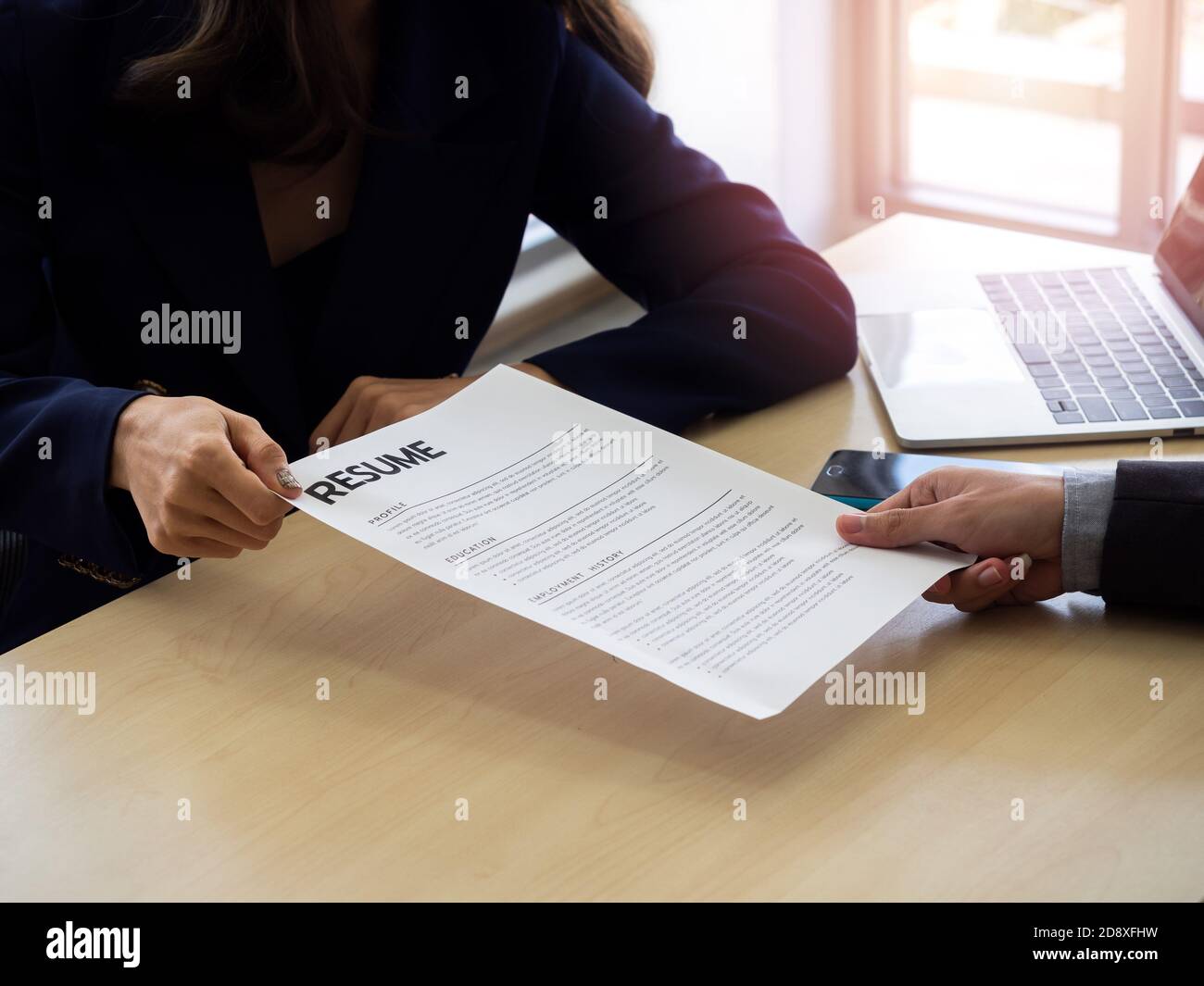Resume or CV paper. Applicant's hand in suit giving resume to employer ...