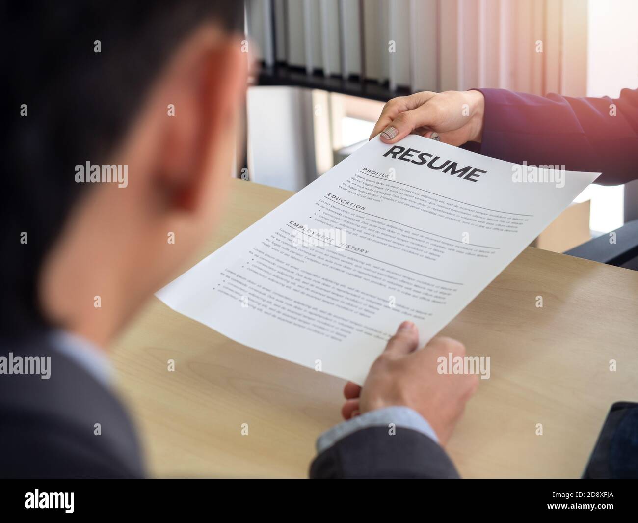 Resume or CV paper. Applicant's hand in suit giving resume to employer ...