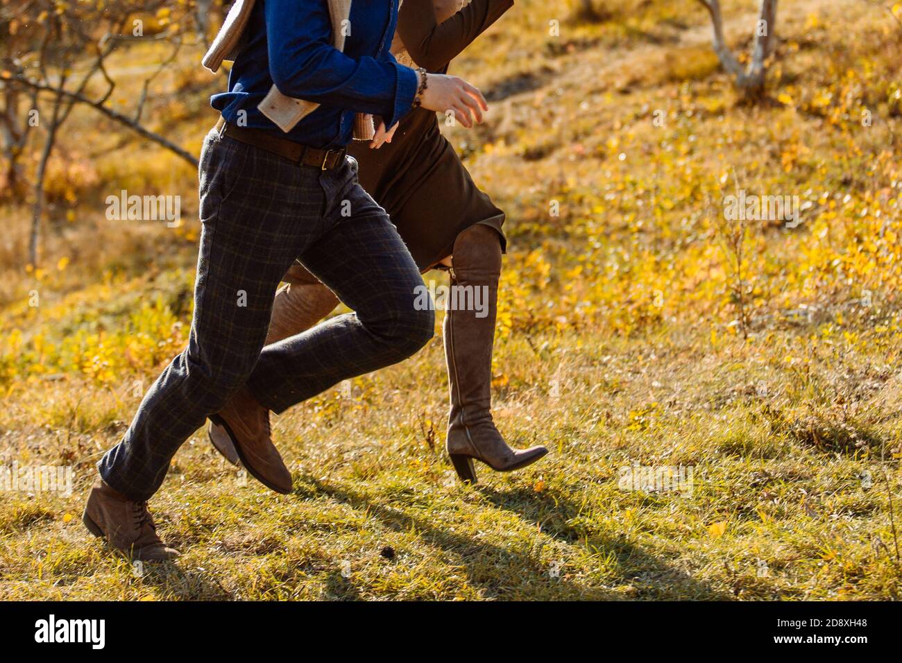 Legs of running people. Couple holding hands and running away. Woman ...