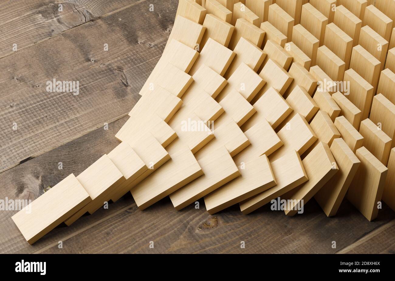 Wooden domino stones pyramid on wood floor falling over, chain reaction ...