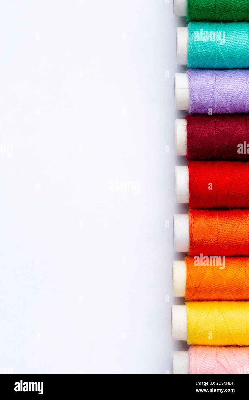 Colorful sewing threads on white background, top view. Spools of thread ...